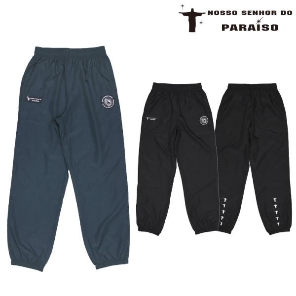 NOSSO SENHOR DO PARAISO の ラインロゴピステパンツ！ノッソセニョールドパライーゾのピステロングパンツです。薄手で軽いピステ生地です。裾にはキリスト像のロゴマークがライン状にプリントされた印象的なデザイン。両ポケット付...