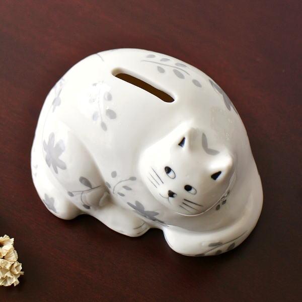 まるく身体を丸めてちょこんとこちらを見上げる猫の姿が可愛い見ているだけで心がほどけるような愛らしい猫の貯金箱つるんとした磁器に花模様をあしらったナチュラルで落ち着いた雰囲気はインテリアとして飾っても絵になりお部屋に優しい空気を運びます見るた...