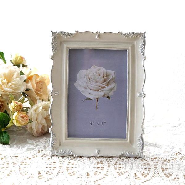 アイボリーホワイトに周りを囲むようなシルバーペイントの装飾がとても清楚なイメージのフォトフレームですシンプルな中にも華やかさを感じるデザインでお気に入りのフレームや小物などいくつか並べてレイアウトすればお洒落な空間づくりが出来そうです商品名...