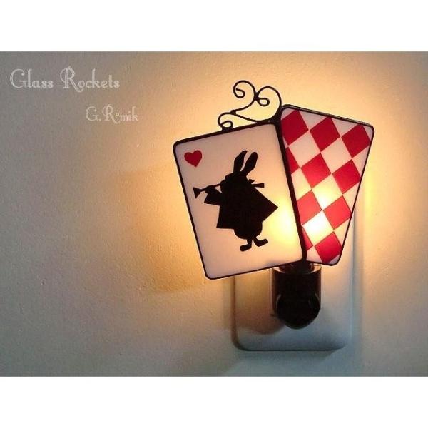 不思議の国のアリス Alice in Wonderlandをモチーフにしたステンドグラスのコンセントランプです。・注：2019/04/13より灯具が最後の写真の白タイプに変更になりました。ご確認お願い致します。・壁のコンセントに差し込んでご...