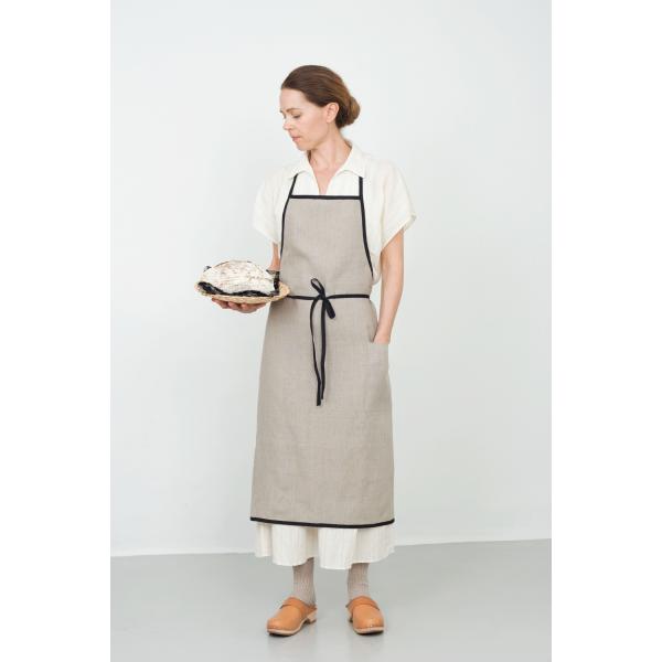 リネンパイピングエプロンパイピングの色がアクセントになって、フェミニンな印象のエプロンです。身幅が狭く、さっと身につけやすいデザイン。お料理教室やお稽古などにも。LINEN PIPING APRONsize: W 85 X L 97 cml...