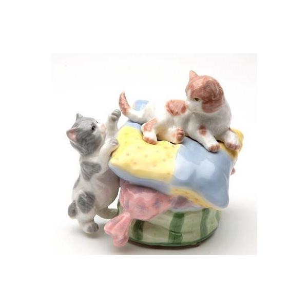 積み上げられたクッションの上で、無邪気に遊ぶ2匹の猫の、オルゴールです♪サイズ(cm)：　縦９．５X横９．２材質：　ポーセリン（陶磁器）オルゴール曲： The Entertainer