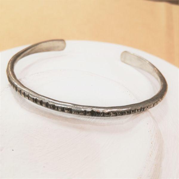 タイのブラス（真鍮製）のバングルです。シンプルながらもハンドメイトならではの味わいのある仕上がり。アジャストタイプのバングルですので、自分に合ったサイズに曲げてご使用いただけます。ハンドメイドのためサイズ・模様・重さは多少の誤差がございます...