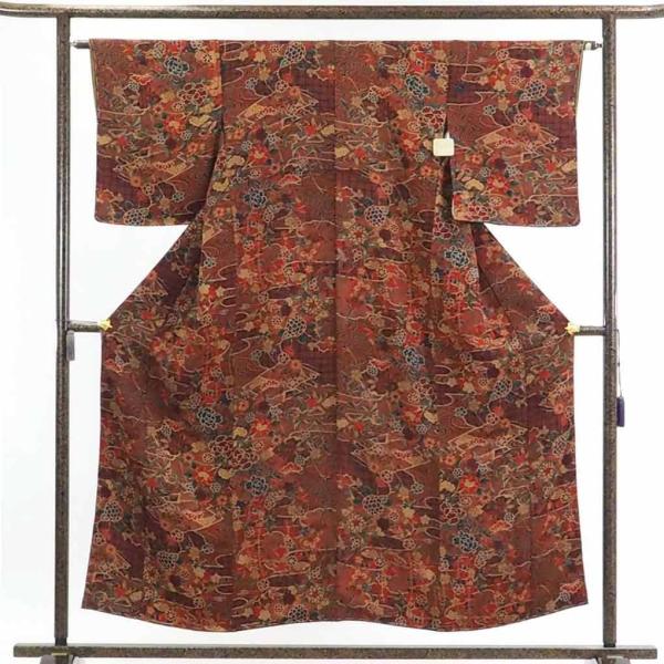 正絹の赤茶寺の袷小紋着物です。シボの大きめの上質なちりめん地を赤みの強い茶色地と花柄で染めたものでカジュアル用途にお召しいただけます。身長149cm-159cm程度、標準体型の方にお勧めサイズです。広衿仕立て。しつけ糸つきの未着用品で特に気...