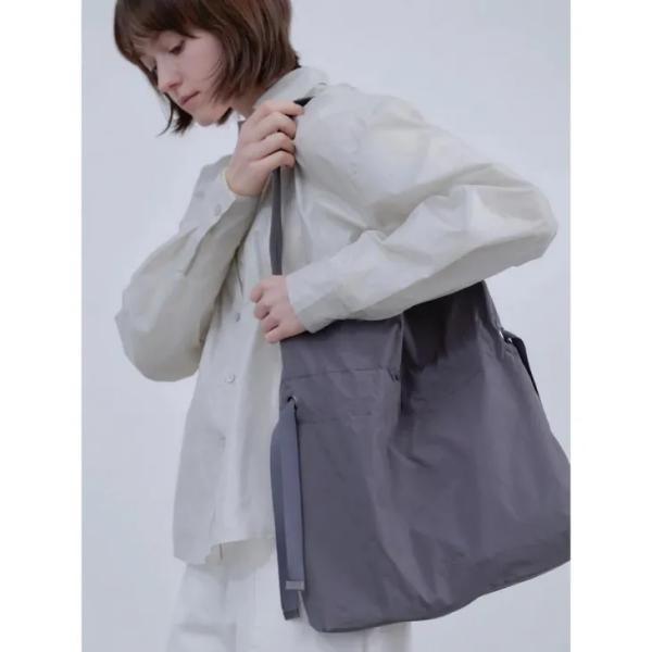 モダンで洗練されたデザインに実用性を兼ね備えたACOCのDRAWSTRINGショルダーバッグ。ノートPCも入るゆったりサイズと、ストリングで2通りのシルエットを楽しめるデザインが特徴で、補強材入りのストラップと底面、エアウォッシングを施した...