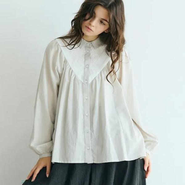 胸元に添えた華奢なレースと、ヨークから流れる繊細なギャザー。まるで遠い記憶の中の風景を描くように、ノスタルジックな空気が漂います。ふわりと膨らむ袖の愛らしさを、 小さな襟がそっと引き締めたデザイン。素材は、エアリーな質感ときめ細かな表面感が...