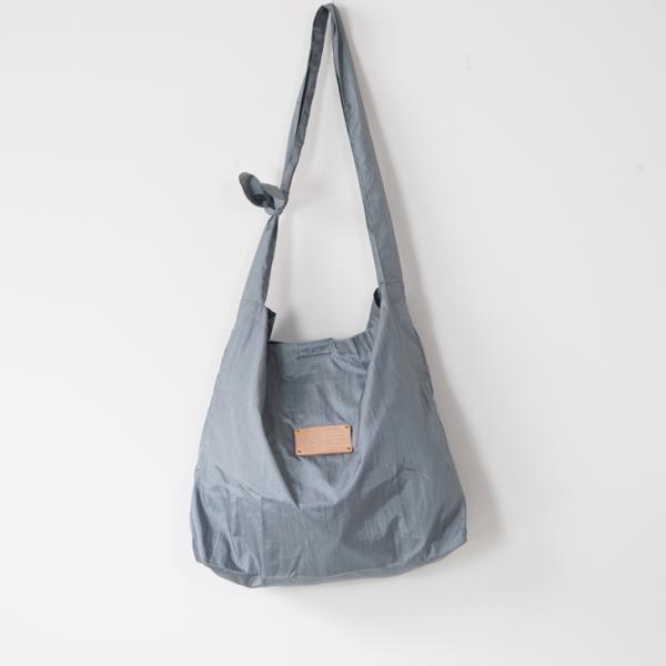 用途に合わせてお好みのスタイルで持つ事ができる ナイロンバッガブルバッグ。 持ち手の長さは結び目を変えるだけなので斜めがけも可能。 ワンポイントに ID カードをモチーフにしたレザータグ。 通常の内ポケット１つと鞄が収納できる巾着ポケット付...