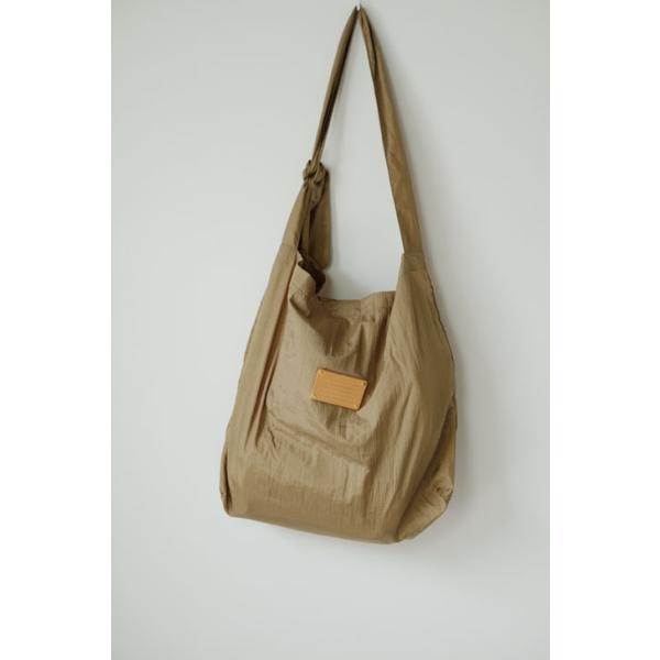 用途に合わせてお好みのスタイルで;持つ事ができる ナイロンバッガブルバッグ。 持ち手の長さは結び目を変えるだけなので斜めがけも可能。 ワンポイントに ID カードをモチーフにしたレザータグ。通常の内ポケット１つと鞄が収納できる巾着ポケット付...