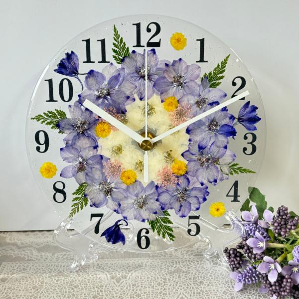 【発売日：2021年05月31日】・押し花をUVレジンでコーティングしたハンドメイドの花時計です。掛け時計・置時計どちらでもご利用いただけます！・円形のアクリル板に数字が印刷してありますので、表面はフラットになっています。ハンドメイドのため...