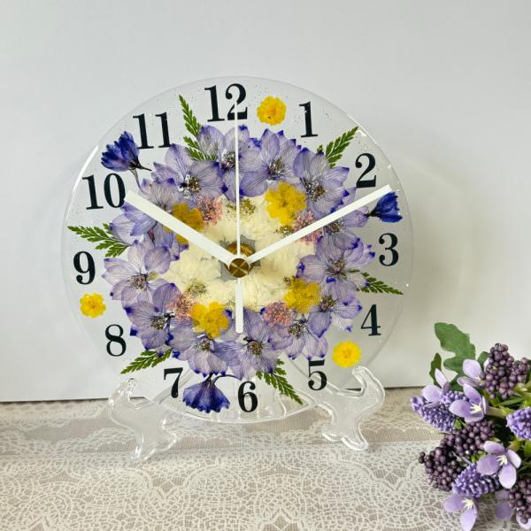 【発売日：2021年05月31日】・押し花をUVレジンでコーティングしたハンドメイドの花時計です。掛け時計・置時計どちらでもご利用いただけます！・円形のアクリル板に数字が印刷してありますので、表面はフラットになっています。ハンドメイドのため...