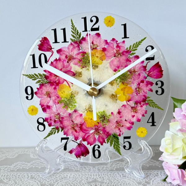【発売日：2021年05月31日】・押し花をUVレジンでコーティングしたハンドメイドの花時計です。掛け時計・置時計どちらでもご利用いただけます！・円形のアクリル板に数字が印刷してありますので、表面はフラットになっています。ハンドメイドのため...