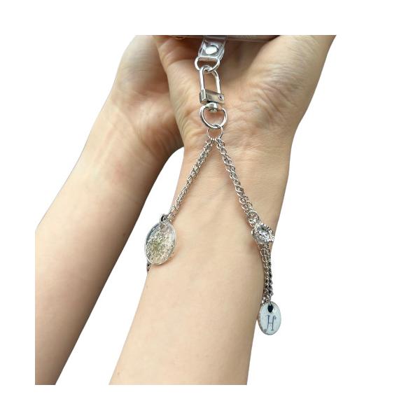 シルバーチェーン2連がスマートフォンを持つ手元を華やかに彩ります。軽くてしなやかなチェーンが肌に優しくフィットし、ストラップ部分もしっかりした作りです。パールチャーム、ラインストーンチャーム、レースフラワーの押し花が入ったリングチャーム、イ...