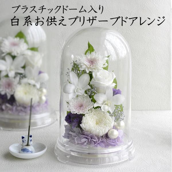 お供え花として人気の白のプリザーブドフラワー（輪菊、デンファレ、ことね菊、白バラ）をメインにした、縦長のプラスチックドーム入りプリザーブドフラワーのお供え仏花アレンジメントです。全てプリザーブドフラワーを使用いたしました。水替え要らずで暑い...