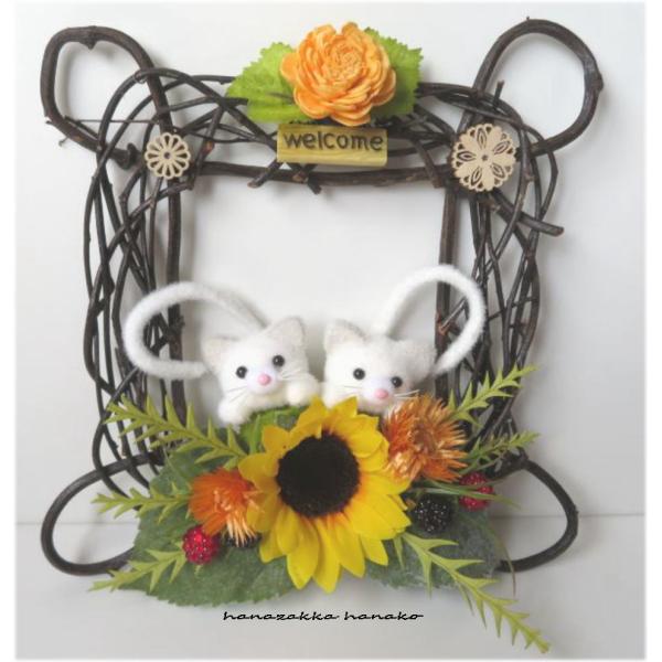 【発売日：2025年04月24日】ネコ好きさんへ　〜ニャンずとひまわり〜　リースアレンジメント∵可愛いお目目の白猫フラワーフレーム♪何かと気にかけてくれる両親や友達へ感謝やお祝いの気持ちを込めてお花を贈って、楽しんで頂きましょう。造花のヒマ...