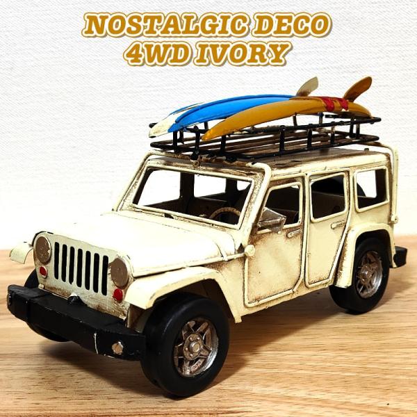 「ノスタルジックデコ 4WD アイボリー」ポップなデザインのおしゃれなヴィンテージカーです。積まれたサーフボードがおしゃれなデザイン。表面はビンテージ加工がされて、ブリキの素材感が味のある仕上がりです。ビンテージ加工されたミニチュアレトロカ...