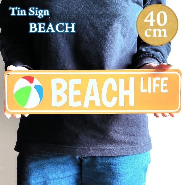 「横長ティンサイン BEACH」鮮やかなオレンジ色がおしゃれな横長ティンサインです！四隅に壁掛け用の穴が開いておりコンパクトなサイズなので、お部屋やガレージ等に気軽に飾ることができます。-アメリカンブリキ看板とは-かつて20世紀半ば経済発展...