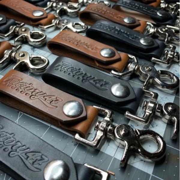 【商品説明】Factory47（ファクトリー47）ロゴの入ったキーホルダーです。ストラップはスナップボタン付きでベルトに装着出来ます。単品販売【カラー】ブラック【商品番号】KF100B