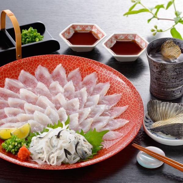 「とらふぐ」を職人の技で美しくひいて盛り付けた刺身のセットです。プラスチックのお皿に盛ることで、リーズナブルな価格でお届けいたします。[商品内容]とらふぐ刺身80g、とらふぐ皮湯引30g（プラ皿25cm）、焼きとらふぐひれ4ｇ、ぽん酢・もみ...