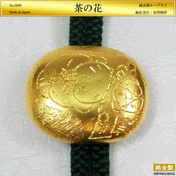 ループタイ「茶の花」の純金製品です。お茶はツバキ科の植物で、白色五弁の小さい花を初冬に開き、満開になると、めしべとおしべがうつむいた感じで下向きに咲きます。花の大きさは直径3〜5cm。本品は、彫金家「帖佐美行」（ちょうさよしゆき）が彫金の技...