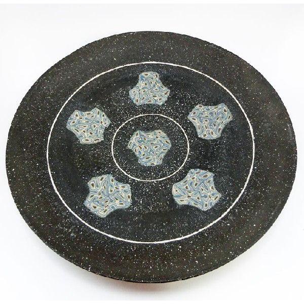 御影土には土の中にいろんな成分が含まれており、本焼きするとその成分が浮き出てきます。特に黒御影土は、黒土荒目で石粒が多めの土で、釉薬（しょうやく）をつけない素肌の感触にも地味な味わいがあり、おもしろい表情を見せます。象嵌（ぞうがん）は、そこ...