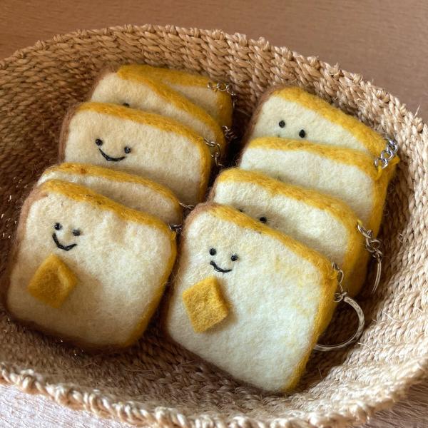 ●食パン　トースト（1個売り）トーストされた食パンにバターがのった可愛らしい顔のキーホルダーです。バッグに付けるのがおすすめです♪●素材は羊毛フェルト100パーセントハンドメイド商品のためサイズや顔つきに若干の違いがございます。サイズ：高さ...