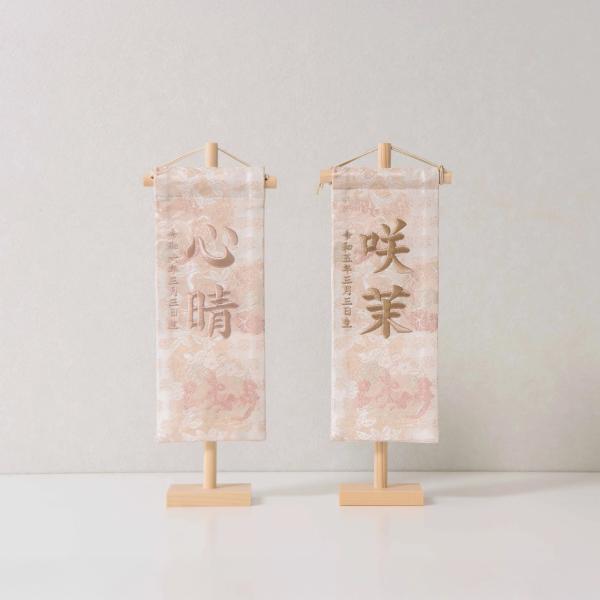 サイズ　｜　高さ29cm雛人形の脇などにお飾りいただく名前旗です。お名前と生年月日を刺繍し、お届けいたします。飾り台は木製、組み立て式でコンパクトに収納可能です。絹織物の産地として名高い、群馬県の桐生織物を使用しています。お名前・生年月日の...