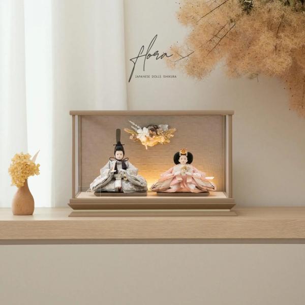 サイズ：横幅46×奥行29×高さ29cmモダンナチュラルなflora(フローラ)シリーズのケース入り親王飾りです。オシャレなラテグレーケースに造花のお花が映えるひな人形です。お人形は平安豊久作、柔らかく自然な着せつけです。お衣装には伝統的な...