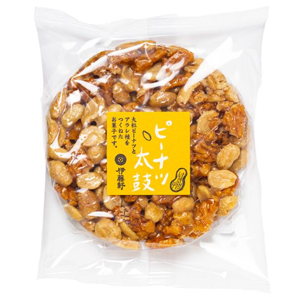 大粒のローストピーナッツと国産米を使ったあられを、飴がけで平たく丸く固めた、昔ながらのお菓子「ピーナツ太鼓」です。カリッ、ザクッとした心地よい歯ごたえと、ピーナッツの香ばしさ、飴がけの素朴な甘みを楽しめます。お茶請けやお子様のおやつにはもち...
