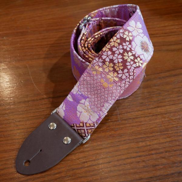 日本を代表する絹織物「西陣織」の布で作ったギターストラップ。色とりどりの先染め糸を用い、彩り豊かに緻密に織り上げられる文様の美しさを生かした一品です。金や銀の糸が織り込まれているため、ライトが当たるとキラキラと光り演奏会などでも存在感を発揮...