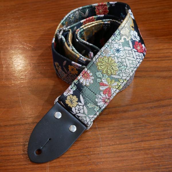 日本を代表する絹織物「西陣織」の布で作ったギターストラップ。色とりどりの先染め糸を用い、彩り豊かに緻密に織り上げられる文様の美しさを生かした一品です。金や銀の糸が織り込まれているため、ライトが当たるとキラキラと光り演奏会などでも存在感を発揮...