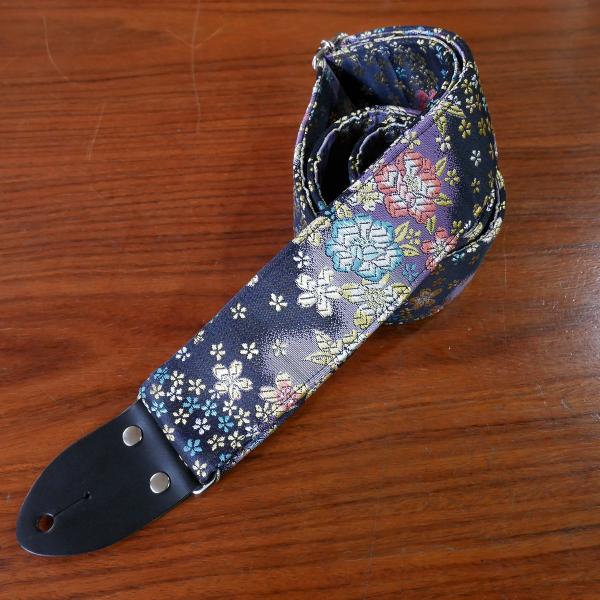 日本を代表する絹織物「西陣織」の布で作ったギターストラップ。色とりどりの先染め糸を用い、彩り豊かに緻密に織り上げられる文様の美しさを生かした一品です。金や銀の糸が織り込まれているため、ライトが当たるとキラキラと光り演奏会などでも存在感を発揮...