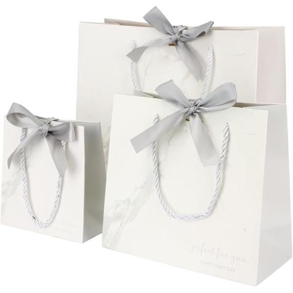 バリエーションコード : 2BJ8R9983V洗練されたデザインが中身をワンランク上に魅せるギフト用手提げ袋です。巾着タイプやボックスタイプなど様々な形状のラッピングに対応できるよう異なる3サイズをご用意致しました。手持ち部分には光沢のある...