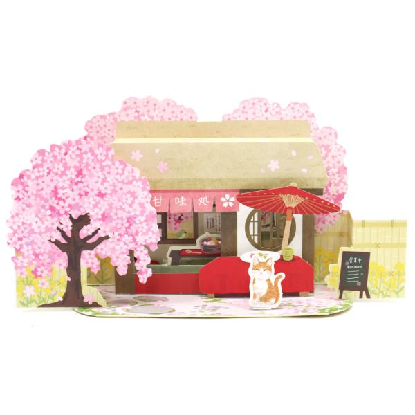 春のお散歩中に、甘味処でひと休み。春の情景をカードに閉じ込めた風景型の立体カード。大きな桜や野点傘、テーブルの上の白玉あんみつなど細かいモチーフまでこだわって描きました。立てて飾れるので春のインテリアとしても楽しめます。◇パッケージサイズ：...