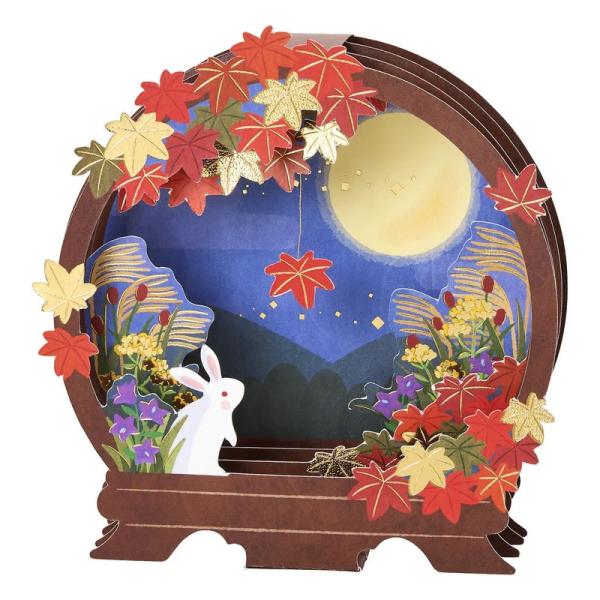 丸棚の中に、月を見上げる愛らしいウサギと満月、紅葉やススキを立体的に描いた和風の秋カードです。全面に美しい金箔加工が施されており、光を受けると上品で華やかに煌めきます。カードの形を整え、底面のタブと裏側のスタンドを起こすことで簡単に立てて飾...
