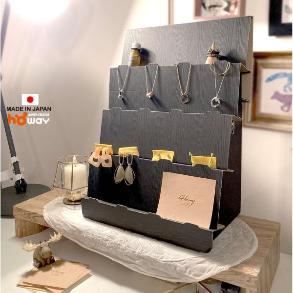 ■特徴■小さなブース用の飾り棚です。簡単に組立可能で、ダンボール製なので破棄もらくらく！ 高級感のある木目柄が特徴です。ポストカードやアクセサリーが下の段に落ちないように段を75度に傾斜をつけています。ネックレスなどはかけて飾ってもおしゃれ...