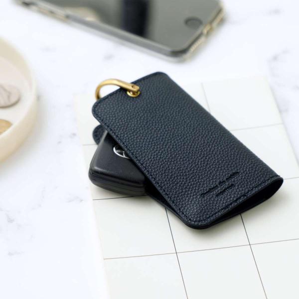 丸い粒の揃ったシボ感が上品な合皮のスマートキーケースです。真鍮無垢のDカンにスマートキーとカギを一緒にまとめられる仕様。内側にスナップボタン付きで、カギをスライドさせる際の開閉もスムーズです。シックな雰囲気とミニマルデザインが魅力で、大切な...