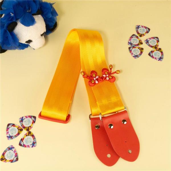 ■デザインアパレルでも流行のチャイナボタンを、ギターストラップにワンポイントで付けちゃいました！滑らかで肌辺りもよいマスタード色のシートベルト素材と、赤いストラップエンド、同じく赤いプラアジャスターでポップにまとめたギターストラップに、蝶々...