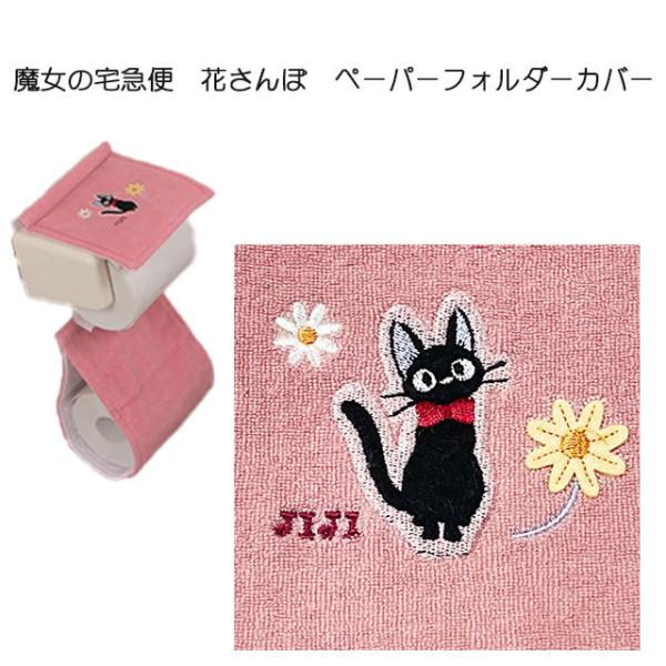 明るいピンク色のベースに花の刺繍と黒猫ジジの刺繍が入ったペーパーホルダーカバー。■サイズ：一本支柱タイプにも対応(※支柱の形状・サイズによっては取付不可)■カラー：ピンク■素材：表生地：パイル/綿　地糸/ポリエステル■生産：中国製
