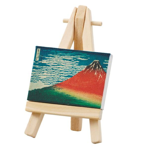 和の名作を、手のひらサイズで楽しむ！葛飾北斎の代表作「凱風快晴（赤富士）」をモチーフにした、卓上サイズのミニキャンバスです。力強くそびえる赤富士の姿が、空間に前向きで明るい印象を与え、日本の縁起モチーフとしても親しまれています。付属のミニイ...