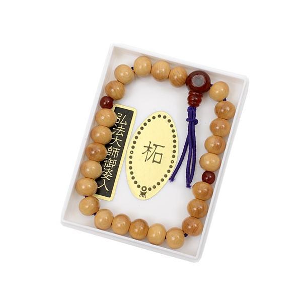 柘（つげ）で仕立てられた腕輪念珠です。メノー色の親玉の中を見ると、弘法大師のお姿が描かれています。透明のプラスチックケース入りです。末永く所持してよいご加護がありますようお祈り申し上げます。■材質＝柘（つげ）■珠の大きさ＝約8mm■通し紐＝...