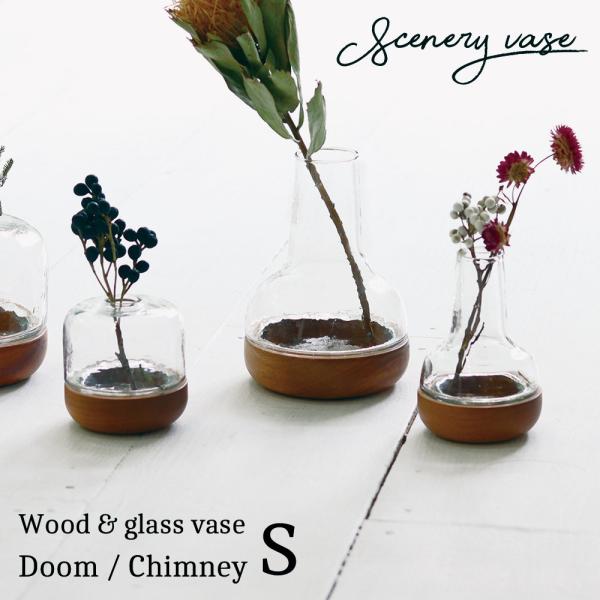 【商品情報】ハンマートーン仕上げのガラスとマホガニー製の土台がセットになったフラワーベースです。ガラスとマホガニーの組み合わせはインテリアにも馴染みやすく、安定感のある形なのでテーブルでのご使用もおすすめです。ガラス部分は取り外しができるの...