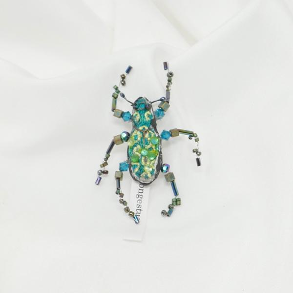 商品発送元：Artistsan online shopその他縦64mm横:40mm重さ:4g糸・地：絹　　ビーズ土台：軽量粘土ゾウムシの表皮は硬く光が当たるときらめく宝石をちりばめたように輝きますので日本刺繍の色銀糸とビーズで表現しました。...