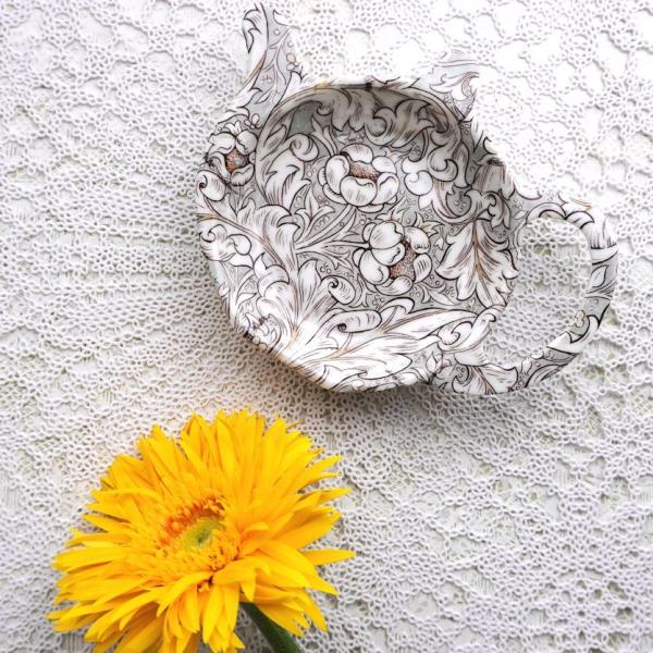 約13×10cm　メラミンイギリスデザイン中国製電子レンジ不可ティーポットの形をした、おしゃれなティーバッグトレイです。こちらはシックなブラウン系カラーのバチェラーズボタン柄になります。ティーバッグをカップから出した後に置くためのトレイです...