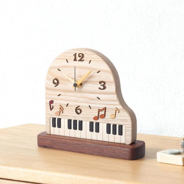 ●デザインインテリアにもなるピアノデザイン、まるみのあるフォルムで暖かみのある置き時計です。シンプルに仕上げた文字盤はとても見やすく、プラスチック板が貼られていないため、照明などの光の反射で見づらいこともありません。●素材無着色の天然木を生...