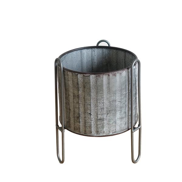円柱形のブリキ鉢に3本脚のアイアンスタンドがセットになった鉢カバーです。ポットはアンティーク調で縦縞(ストライプ)模様が凸凹加工で入っています。サイス：幅14×高さ18×奥行14cm／ポット：直径12.5(11.8)×高さ10cm　材質：ブ...