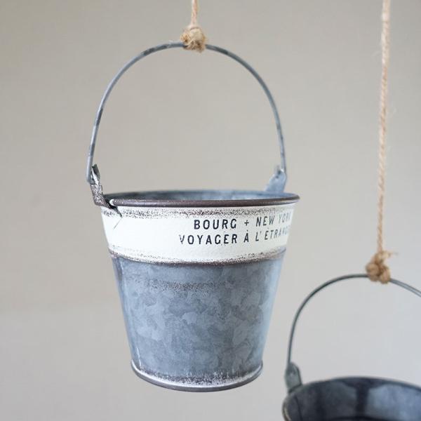 3号ポットが入るバケツ形ブリキ鉢。サイズ：幅10×高9.5)(18)×奥行10m/口径10.3cm　材質：ティン　製造：中国　底穴：1ケつや消しシルバーのブリキにアンティーク調にペイントした白のラインにダークブランでロゴが入っています。ロゴ...