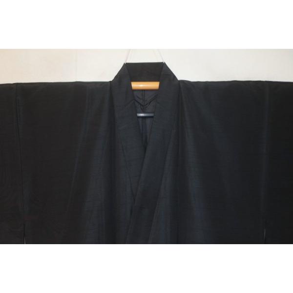 　こちらのお品は、シルク化繊丹後縮緬調のお召の袷の着物です。ミシン手縫い併用の呉服仕立ての新品です。着物のみです。化繊の染物調ですが、本絹並みです。むしろ本絹より扱いやすいかもしれません。黒の無地感です。裏は平絹に化繊のサテン地で八掛のよう...