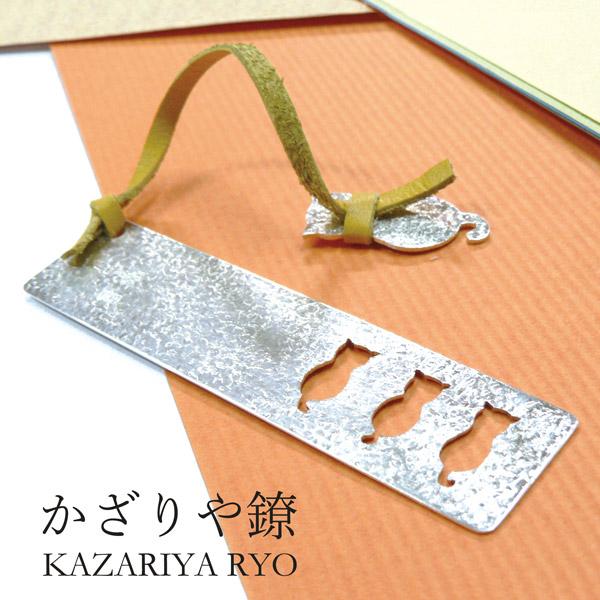かざりや鐐 kzr-d-004 しおり「猫物語 3匹」【かざりや鐐 しおり「猫物語 3匹」】純銀を使用したしおりです。「猫物語」シリーズ後姿が透かしてあります。ずり落ち防止に革紐で子猫がついています。※紐の色はランダムです。ご了承ください。...