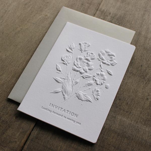 アネモネ、ベビーコスモス、スプレーバラの3種の花々をあしらった上品なデザインの二つ折りカードに、封筒と中紙がセットになった招待状です。