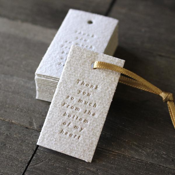 モコモコとした手触りのグレーの起毛紙に活版印刷で制作したサンキュータグです。裏地には印刷カラーと同系色でクロコ調のテクスチャがユニークな紙を貼り合わせております。紙質と活版印刷特有の凹んだ文字がとても個性的なタグに仕上がっております^^プレ...